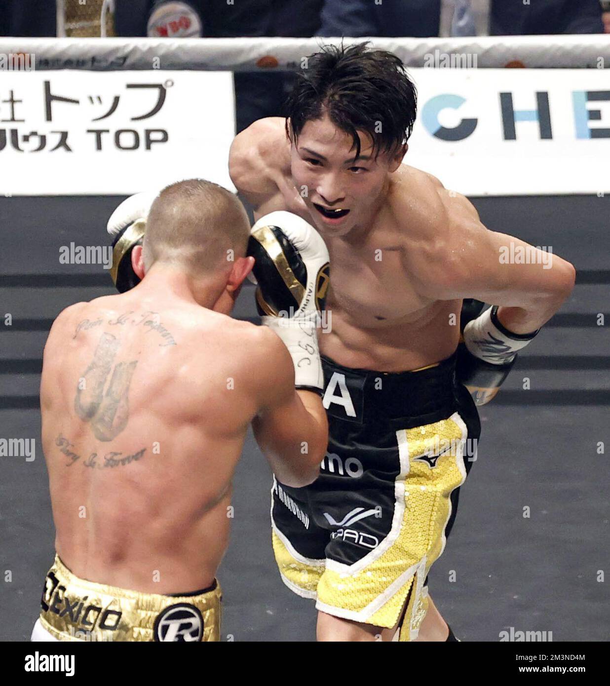 Japan's Naoya Inoue (R) puts his hands behind his back and sticks his ...