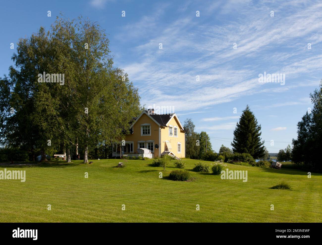 A yellow wooden house in the Nordic countryside. Garden, park this side ...