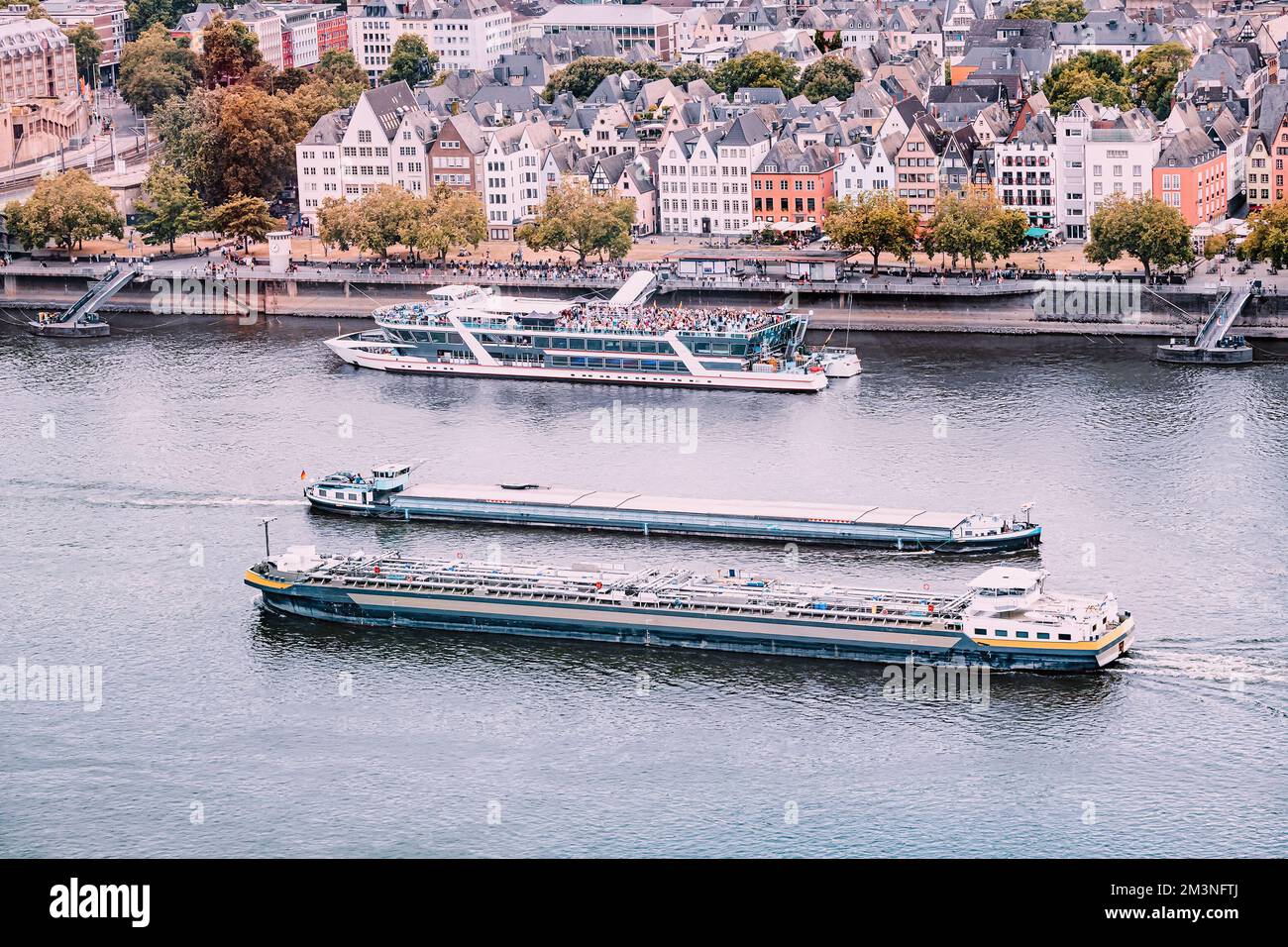 Cargo barges and ships transport industrial goods along the Rhine River ...