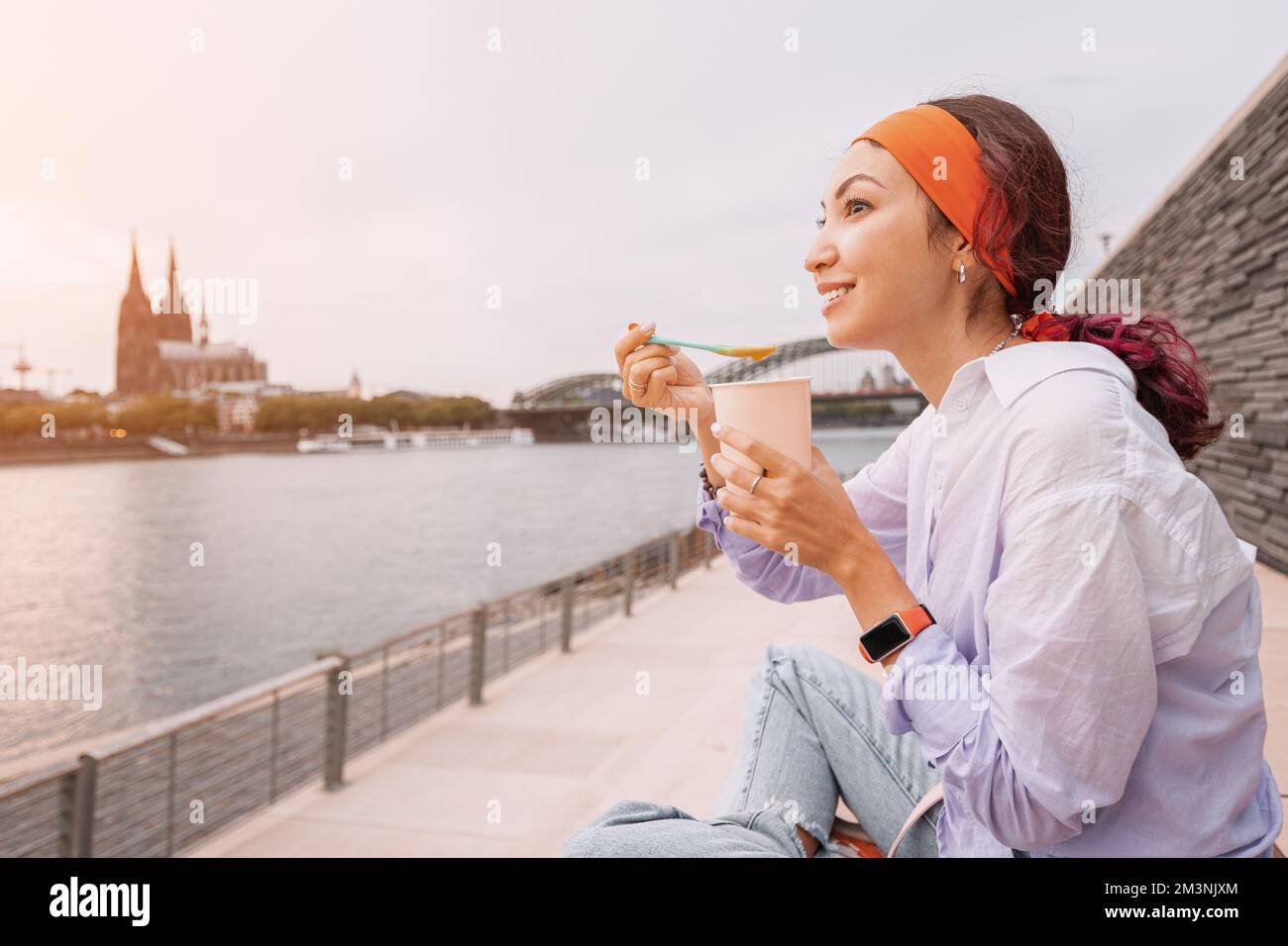 A girl snacking on fast food takeway with a mug of vegetarian pumpkin ...