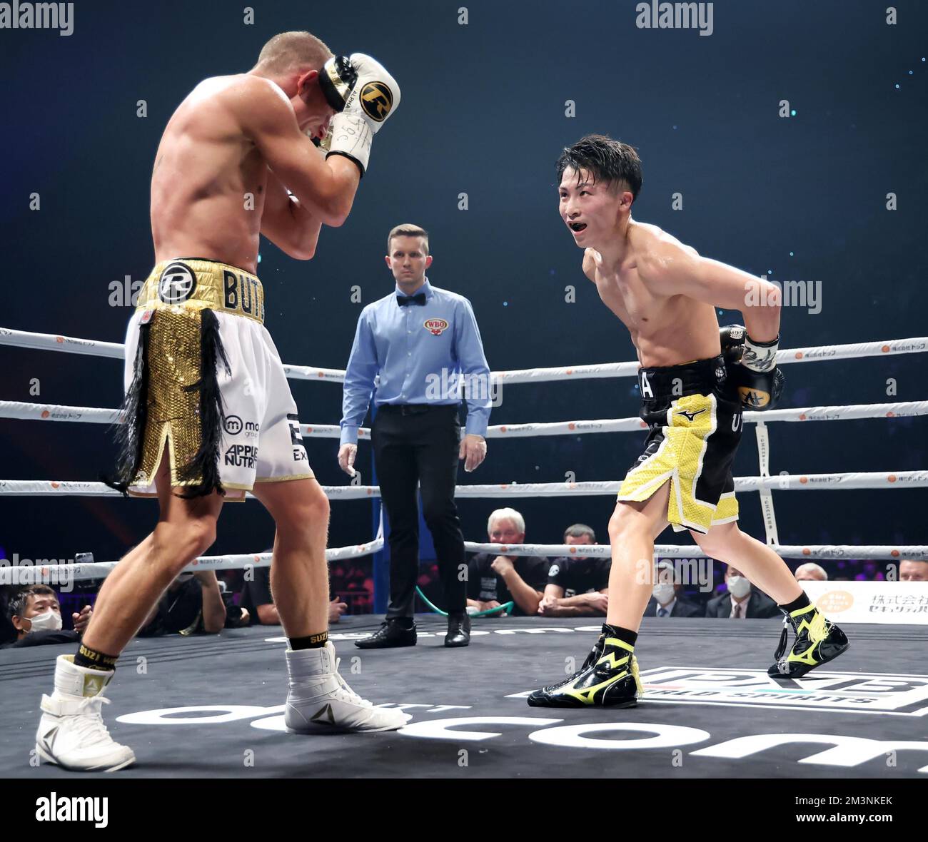 Japan's Naoya Inoue (R) puts his hands behind his back and sticks his ...