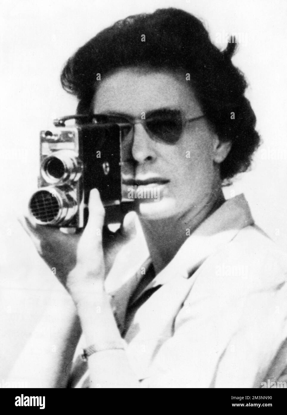 Queen Elizabeth II using a cine camera to capture the action at an ...