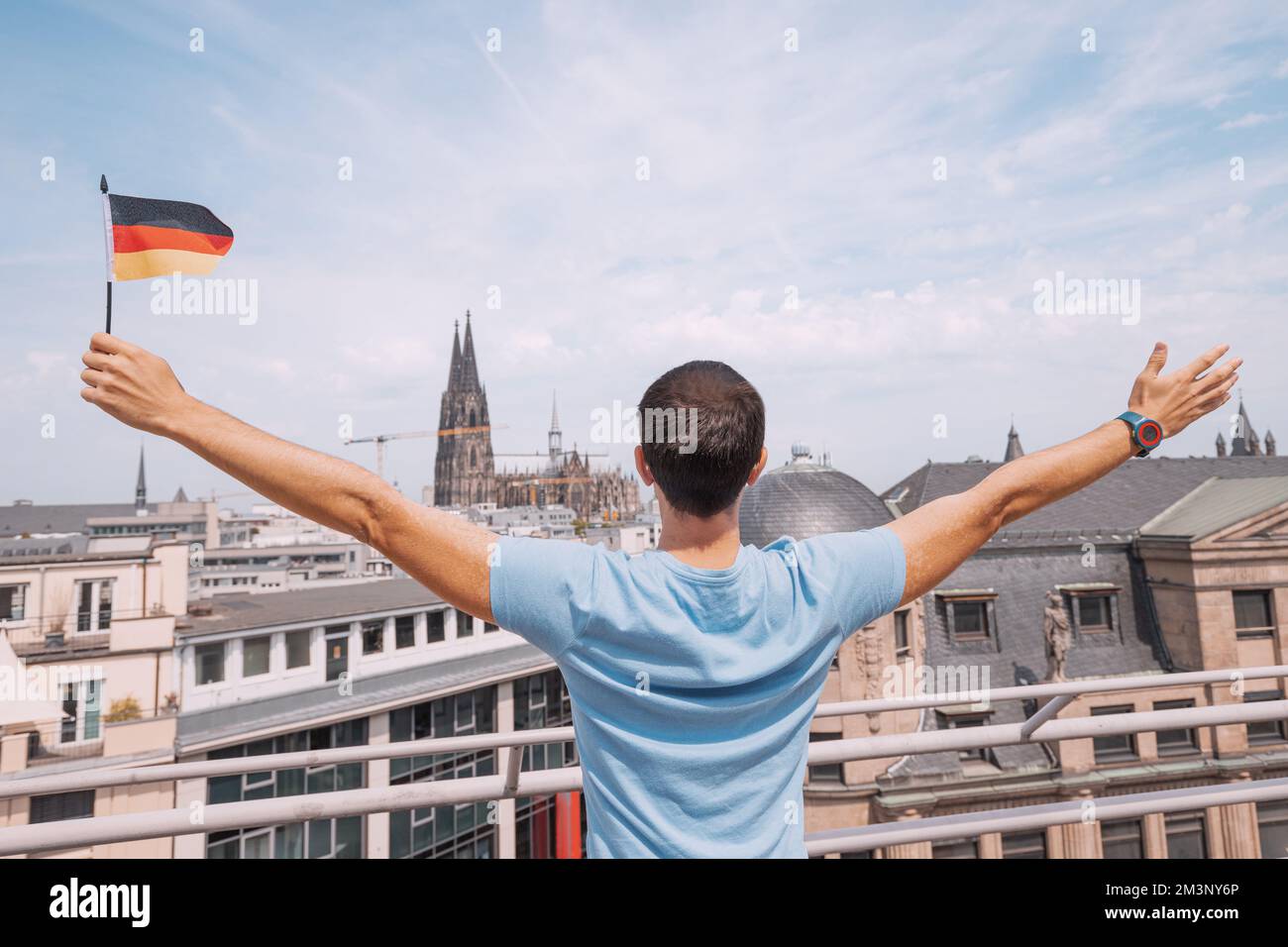 Happy man with a German flag against the roofs of the old town and ...