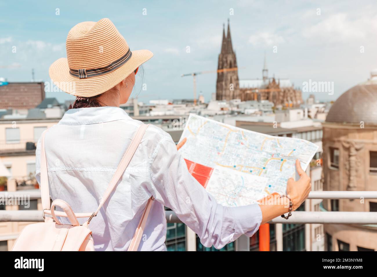 Tourist girl with maps, navigating for sights and landmarks and ...