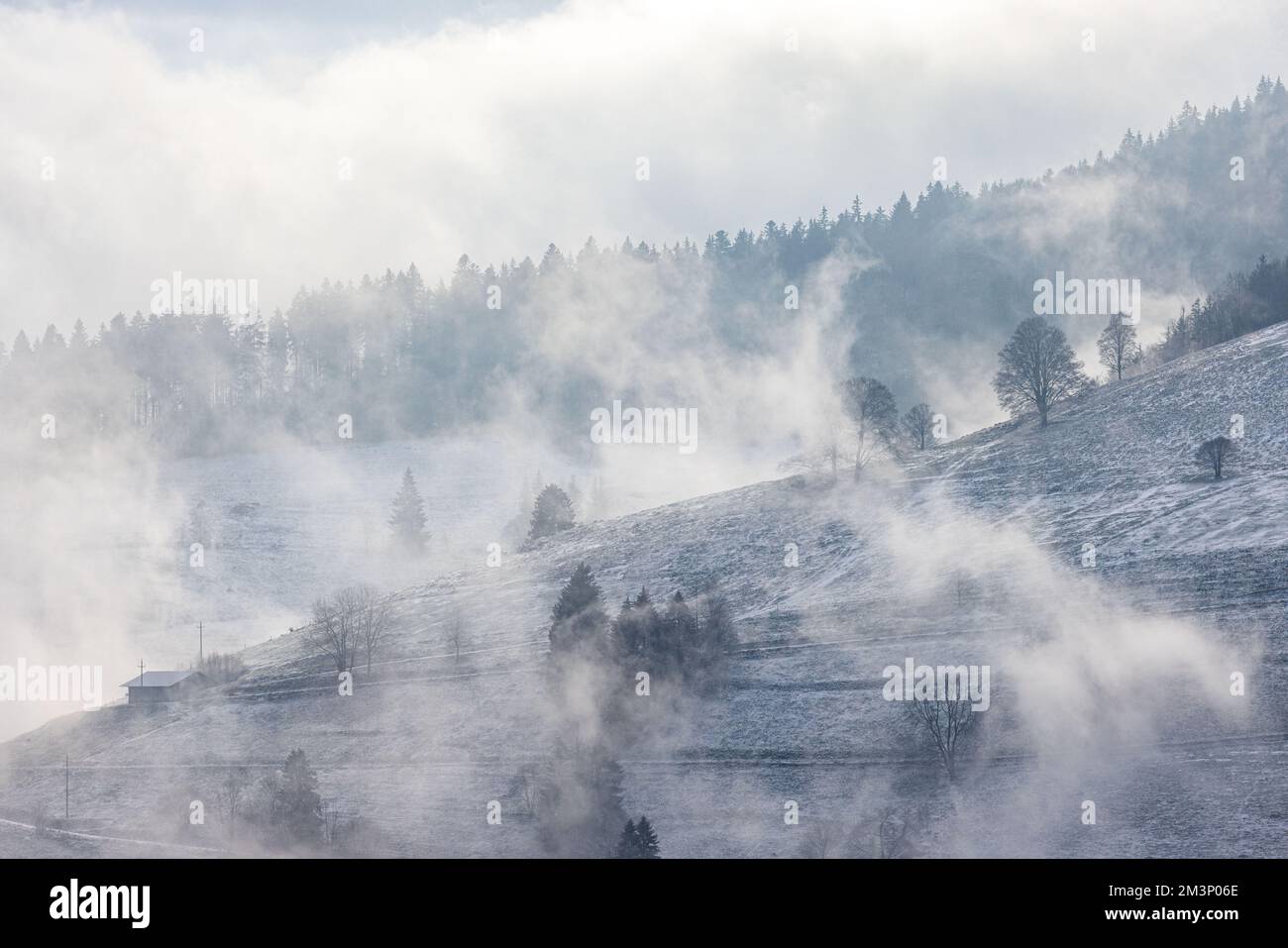Todtnau, Germany. 16th Dec, 2022. Wisps of clouds drift across a snowy ...