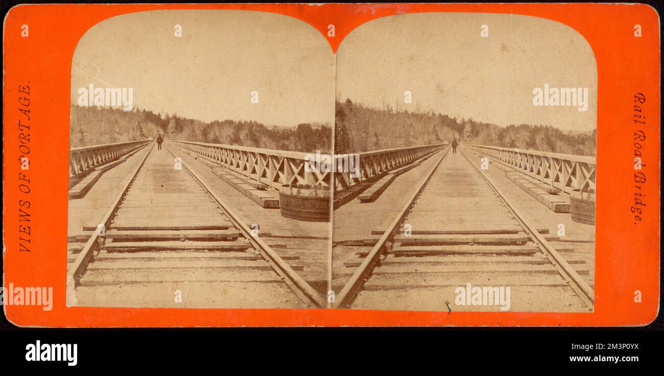 Railroad bridge, with a man standing on the tracks in the distance ...