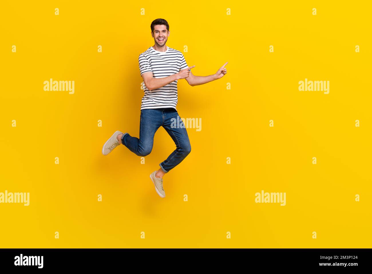 Full length photo of cheerful cool guy dressed striped t-shirt pointing ...