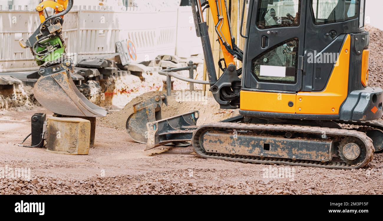 Small excavator working on a construction site at city street ...