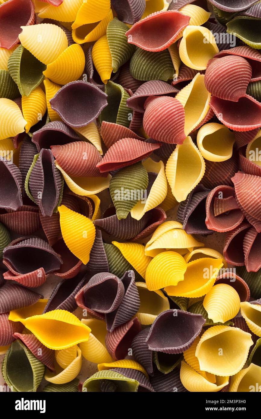 Colorful pasta background. Top view of five colors pasta shells on ...