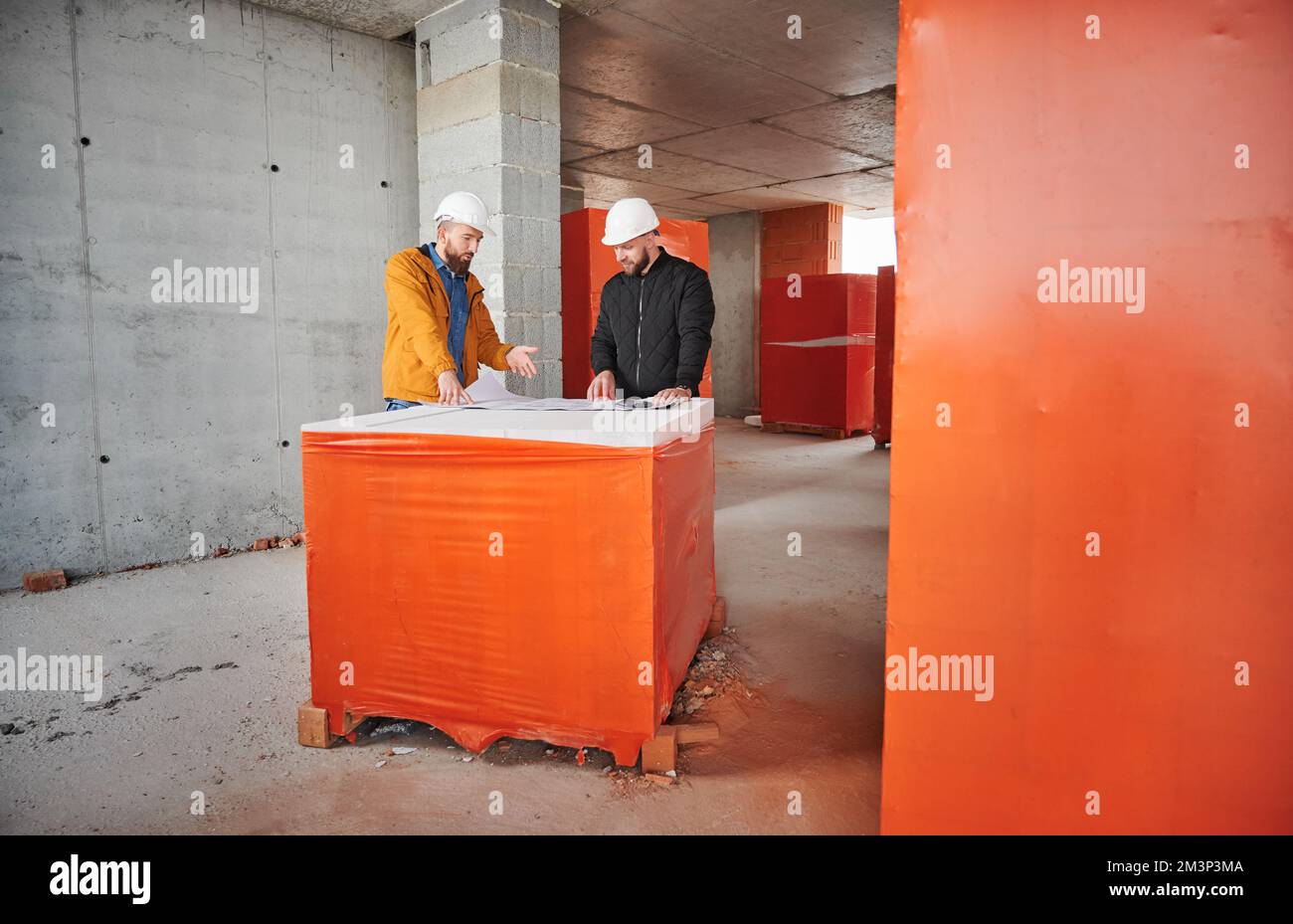 Man discussing architectural plan of new apartment with construction ...