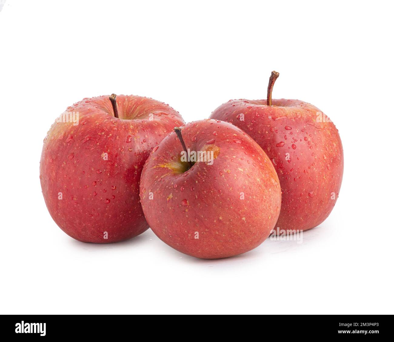 Three red fuji apples in water drops on a white isolated background ...