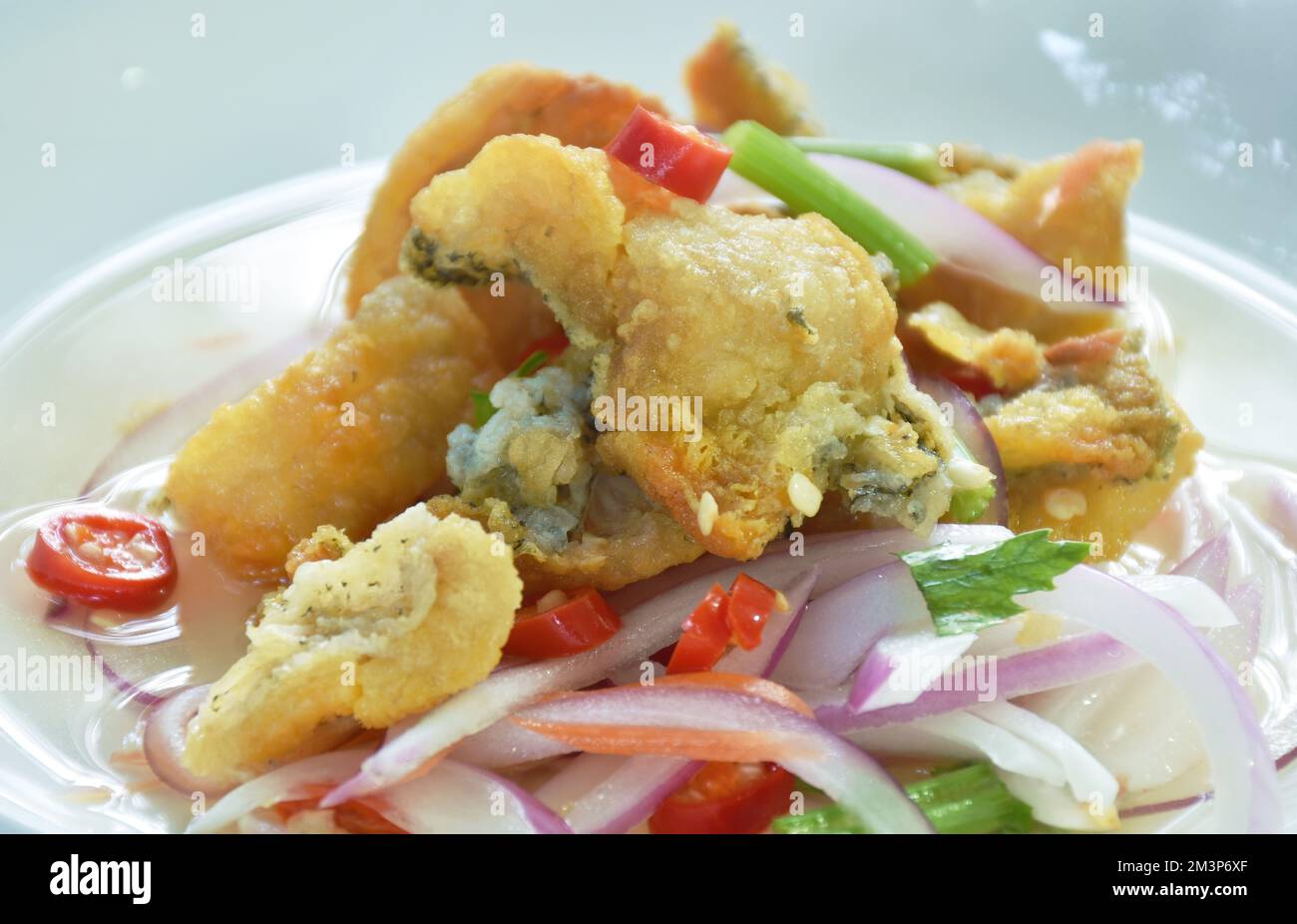 deep fried slice snake skin gourami spicy and sour Thai salad on dish ...