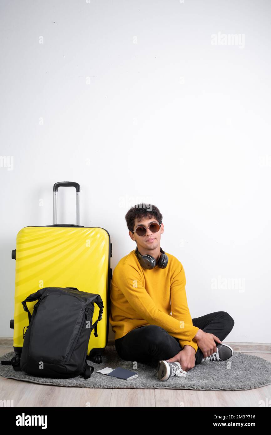 Traveler tourist man wear yellow sweater sitting near suitcase bag ...