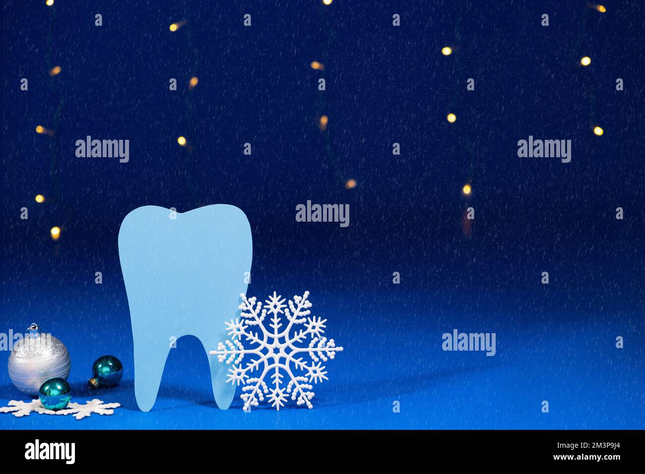 Christmas dentistry - tooth, snowflakes and balls on a blue festive ...