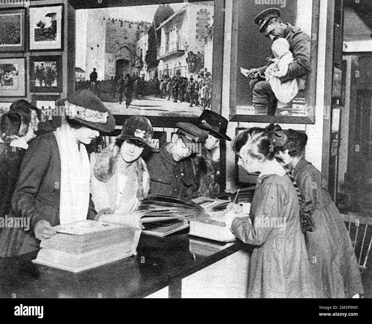 Customers inspecting picture albums at a new bureau for the sale of ...