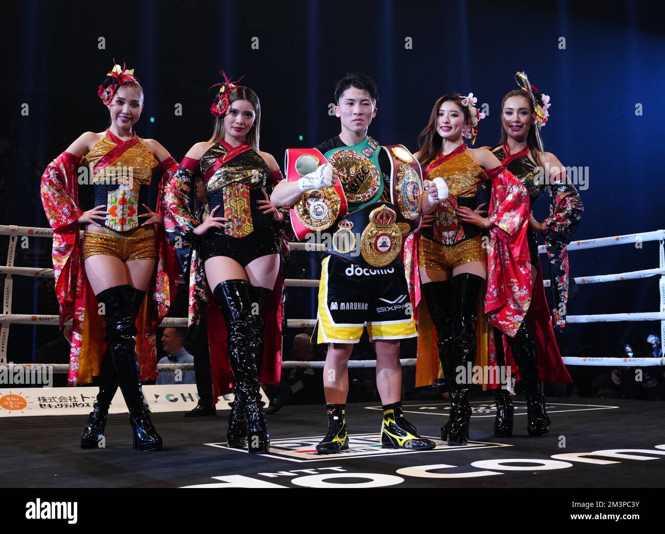 Japan's Naoya Inoue (C) stands between ring girls with his four ...