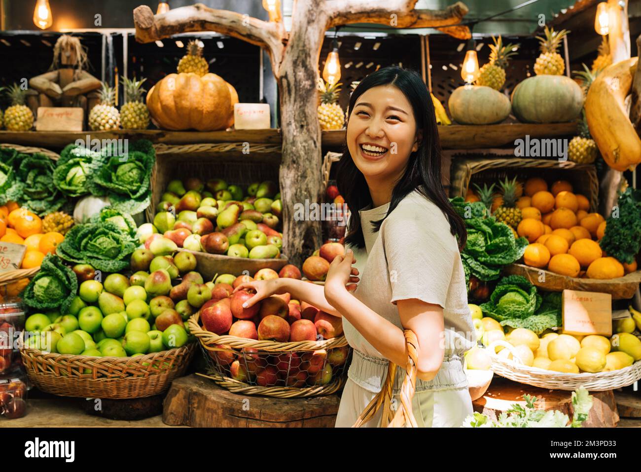 Laughing Asian woman on an outdoor market. Smiling female buying ...