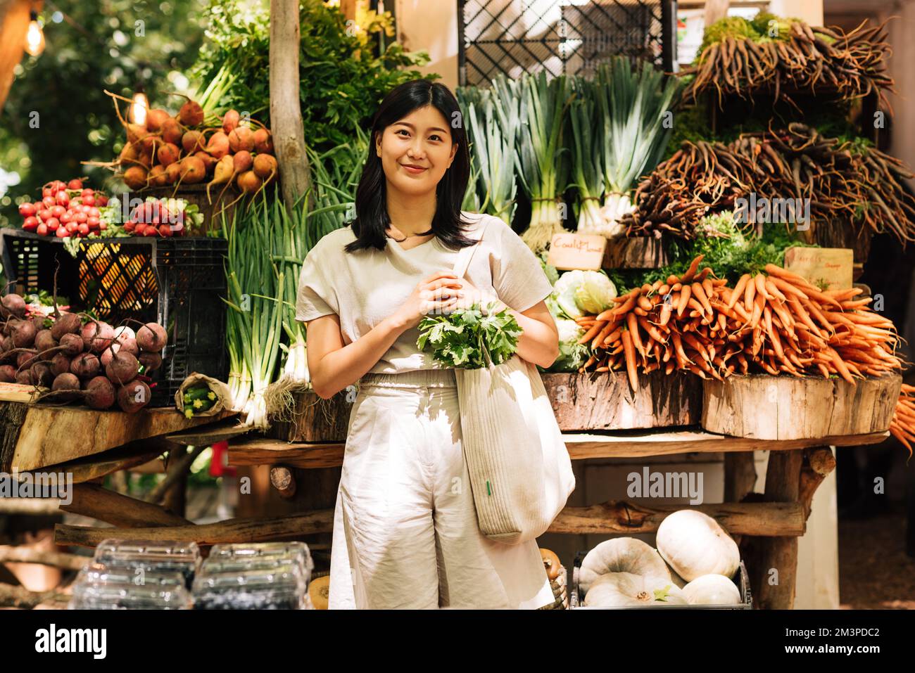 Young woman with a shopping bag on an outdoor market. Female customer ...