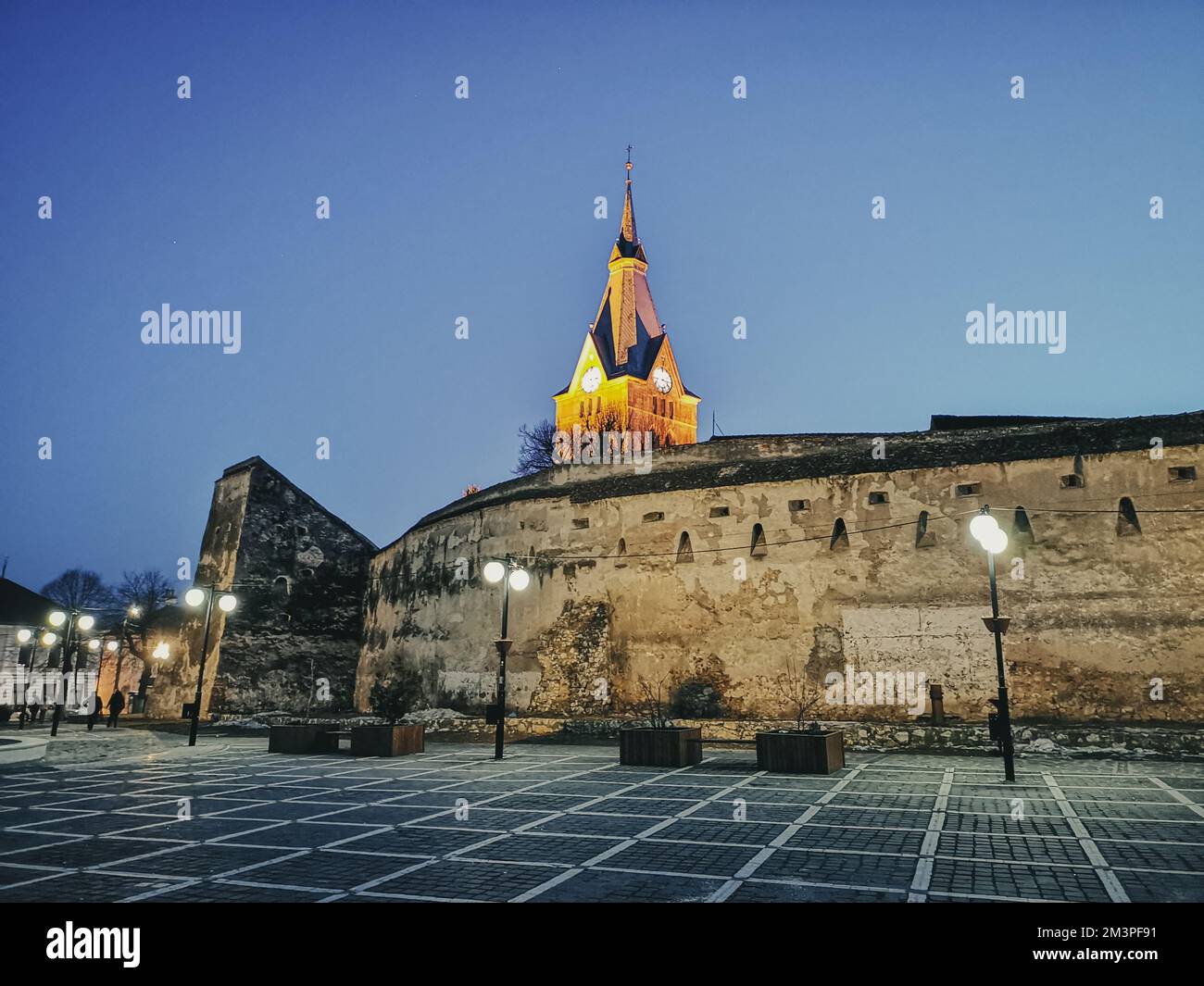 A beautiful monastery in the background of an alley with street lamps ...