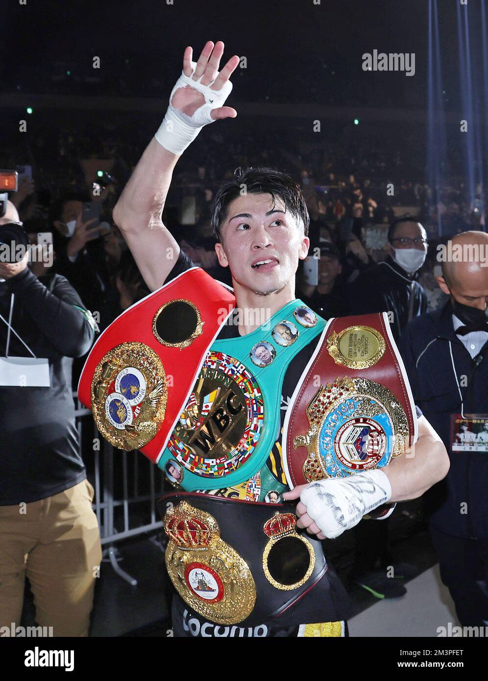 Japan's Naoya Inoue waves to the crowd holding his four champion belts ...