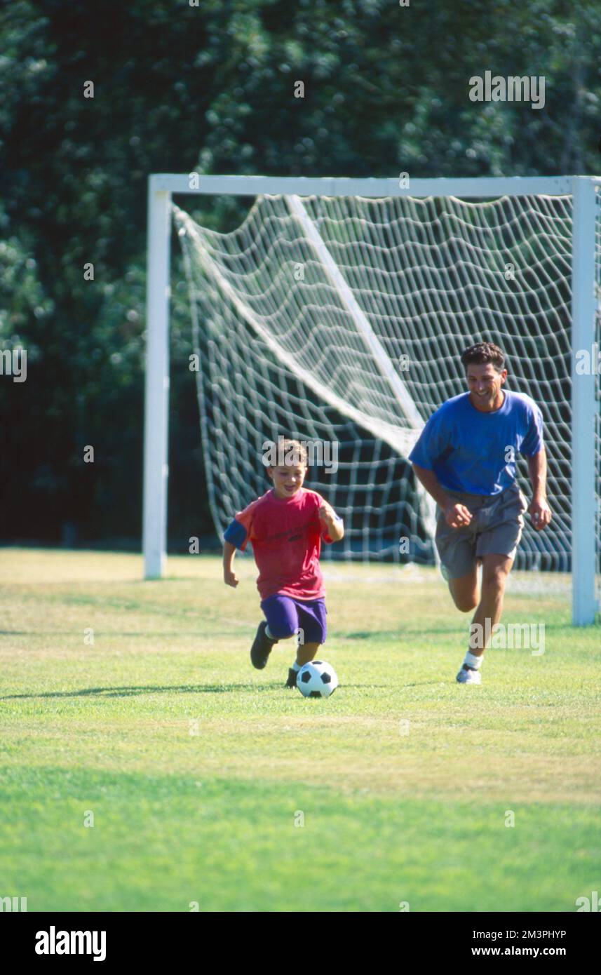 Father and son outside playing soccer Stock Photo - Alamy