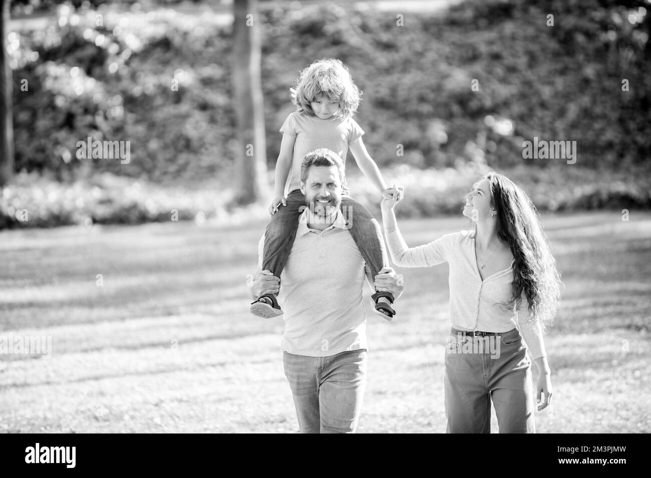 Happy family of mother and father carrying boy child on shoulders ...