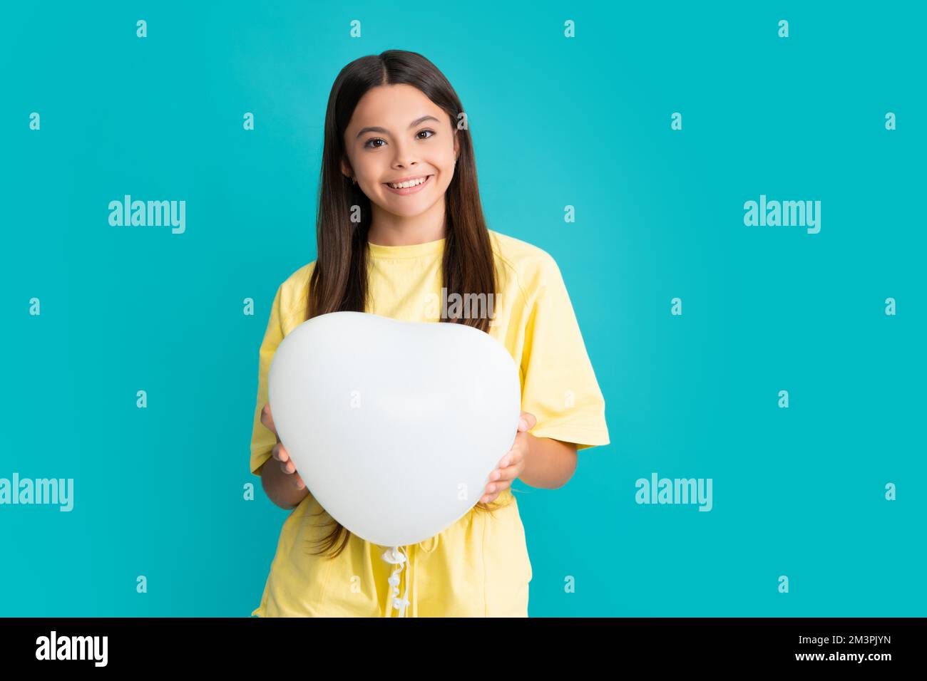 Lovely little teen girl playing with red heart shaped balloon. Happy ...