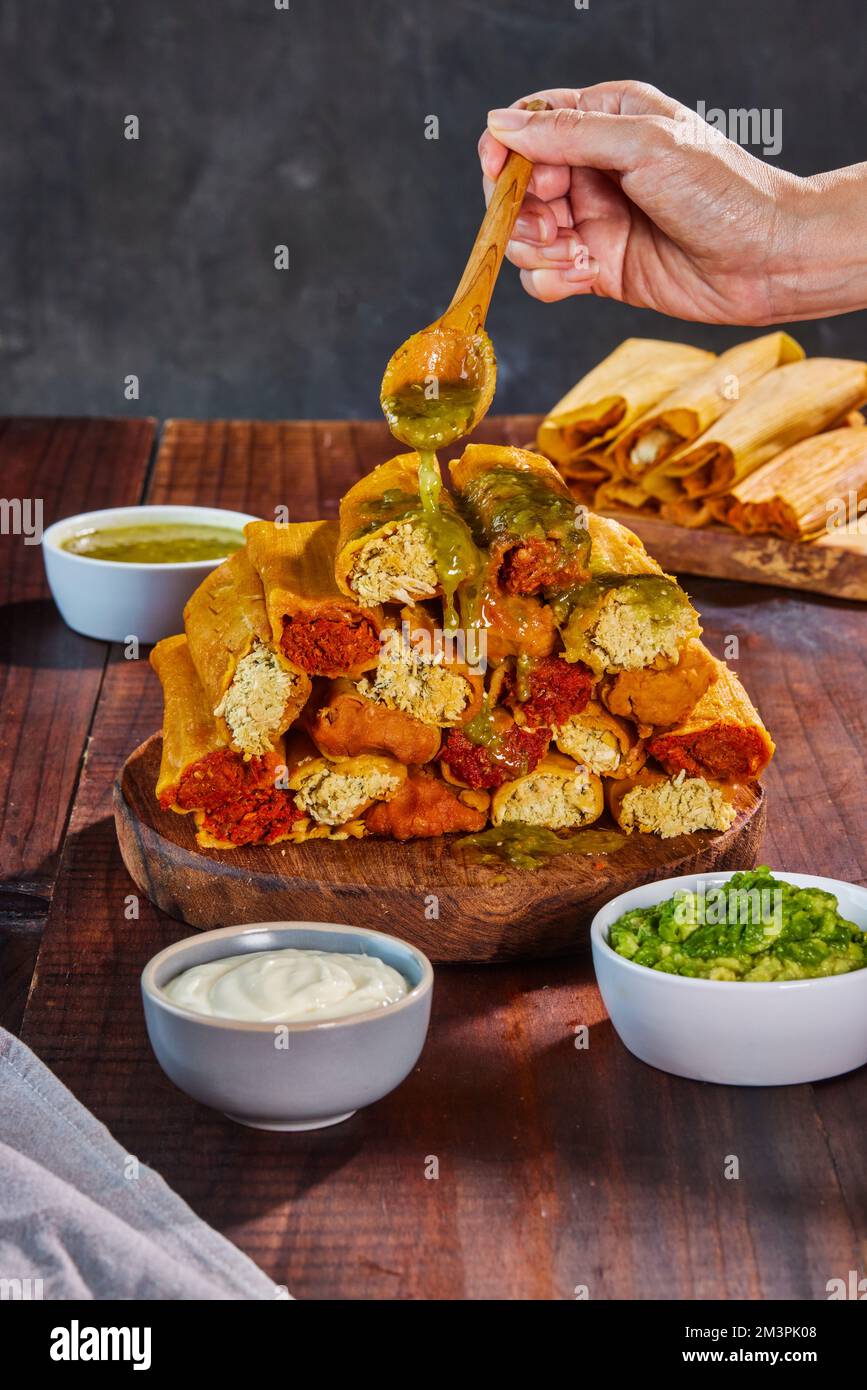 A vertical closeup of a chef pouring sauce on a burrito stack Stock ...