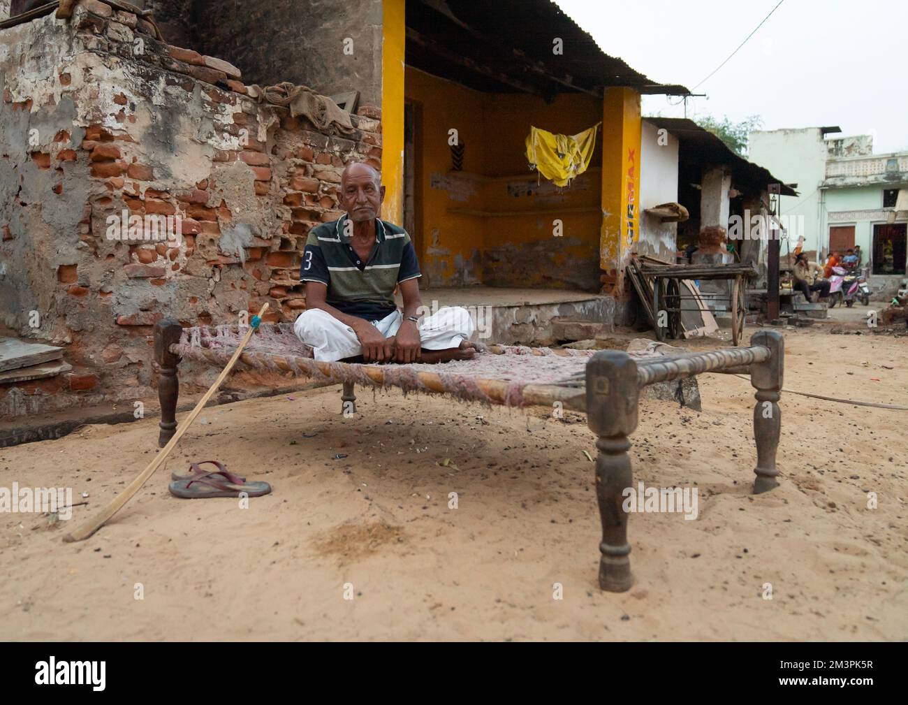 Indian man sit ona traditional bed in the street, Rajasthan, Mukundgarh ...