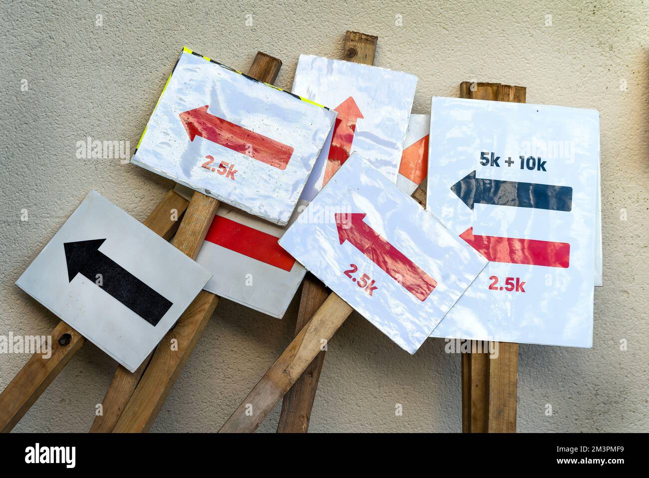 Arrow distance sign placards for giving direction in a heap against a ...