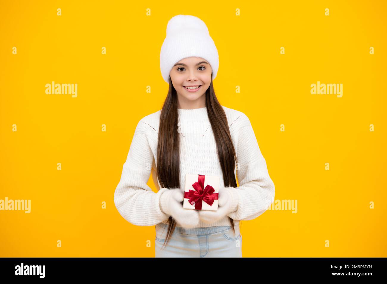 Teenager child holding gift box on yellow isolated background. Gift for ...