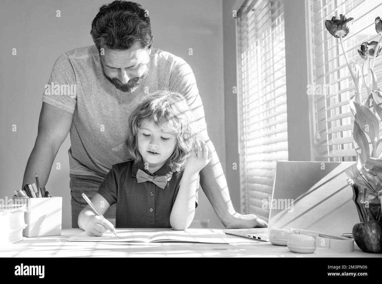 bearded dad writing school homework with his kid son in classroom ...