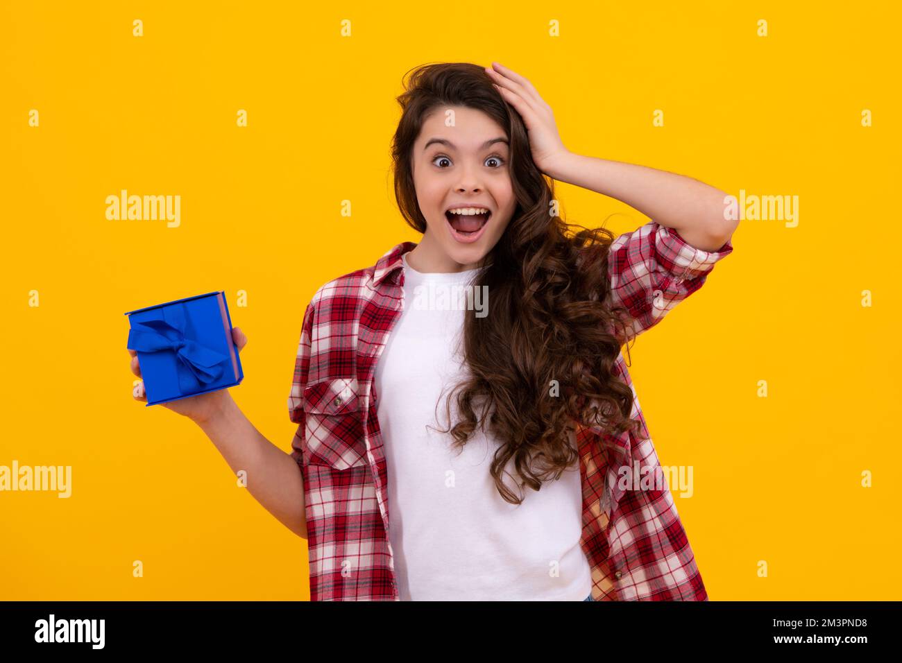 Amazed teenager. Child with gift present box on isolated studio ...