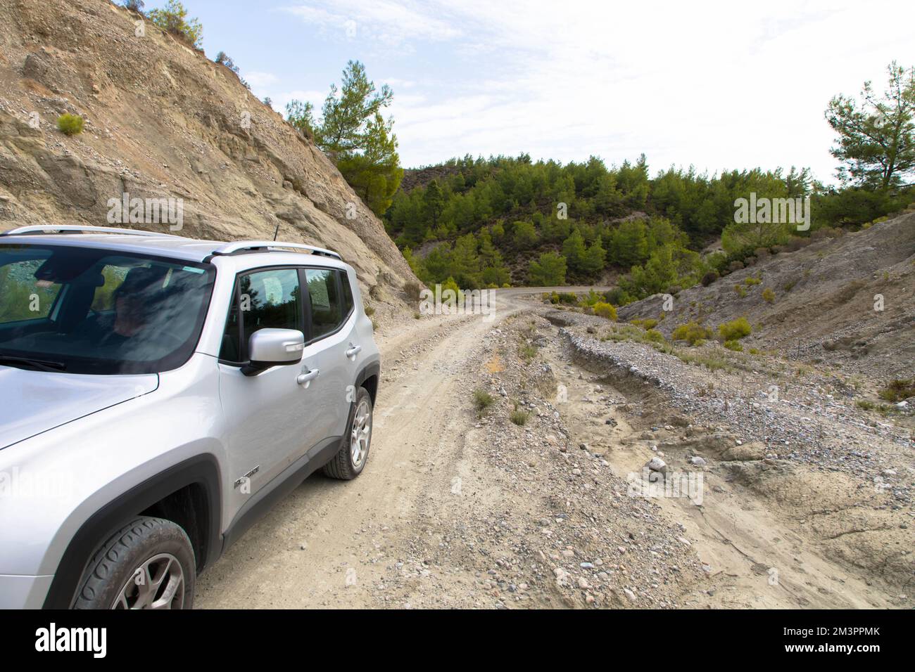 Vacation with a rental car. 4x4 off-road Jeep Renegade on dirt road on ...