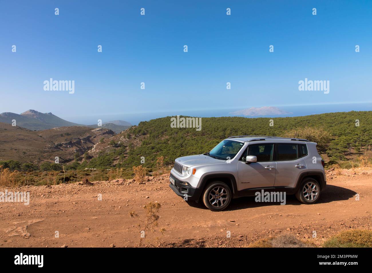 Vacation with a rental car. 4x4 off-road Jeep Renegade on dirt road on ...
