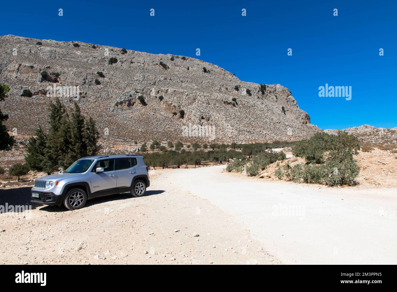 Vacation with a rental car. 4x4 off-road Jeep Renegade on dirt road on ...