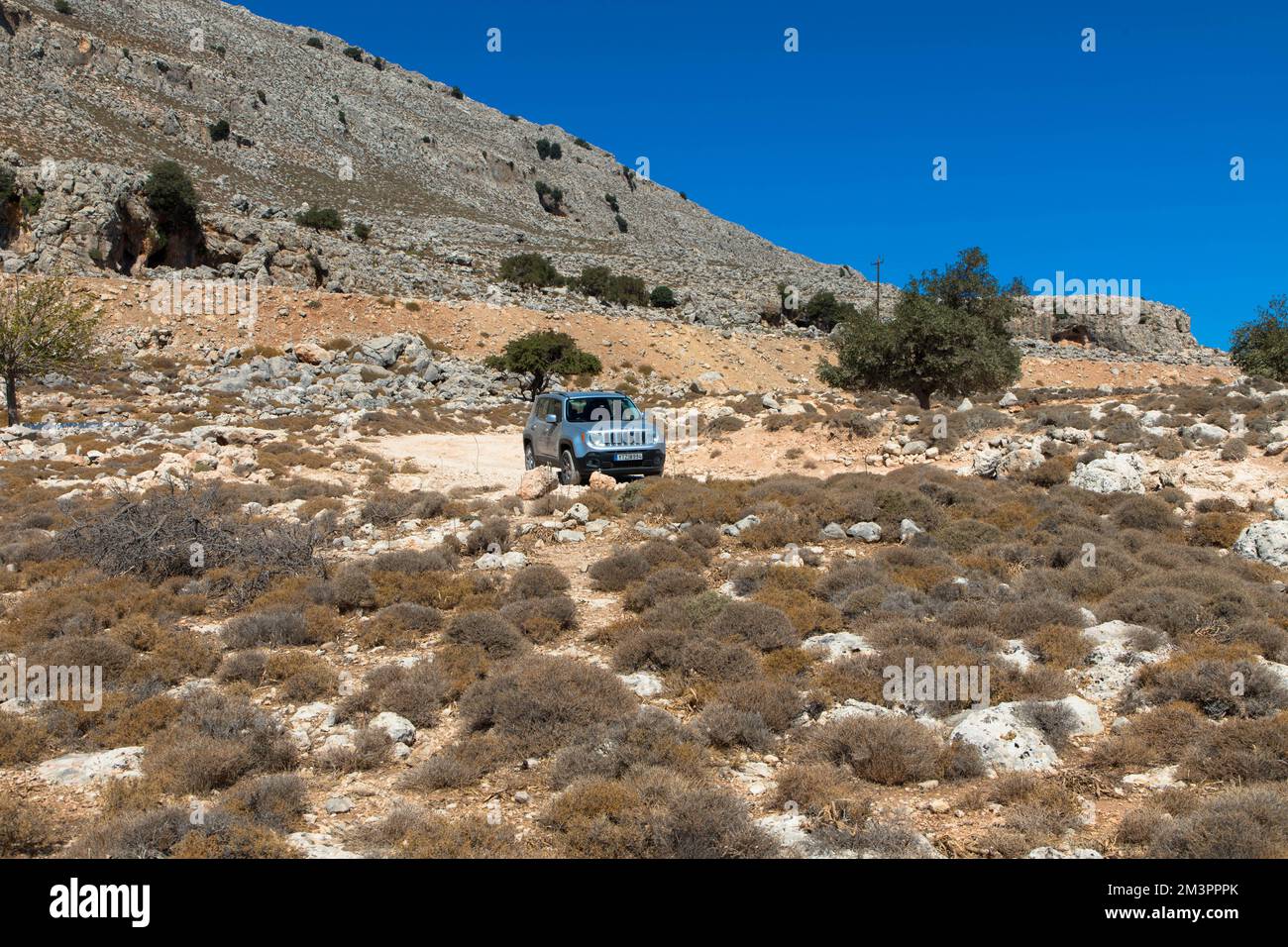 Vacation with a rental car. 4x4 off-road Jeep Renegade on dirt road on ...