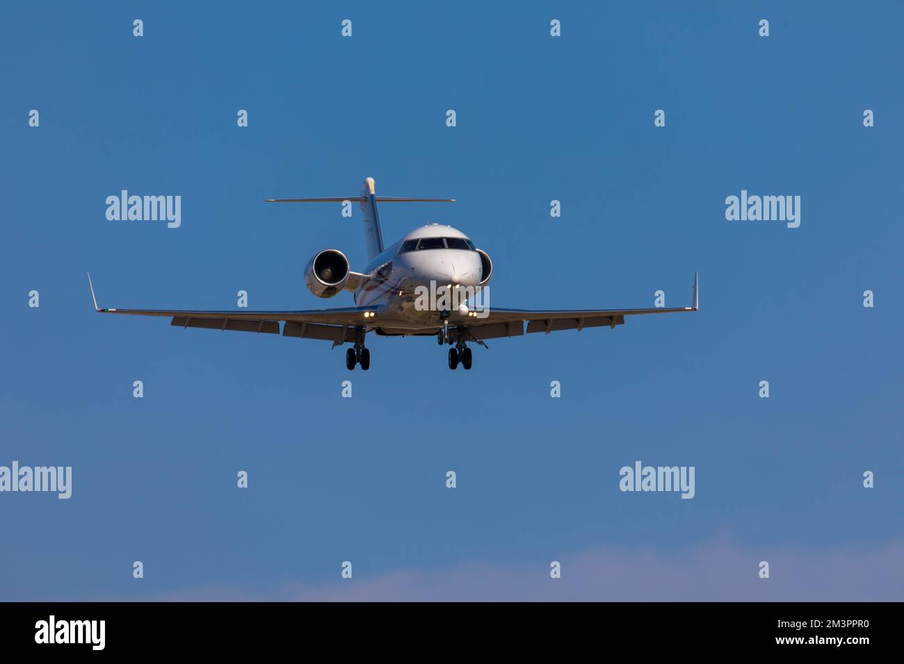 Private jet on approach for landing. Blue sky with plenty of space for ...