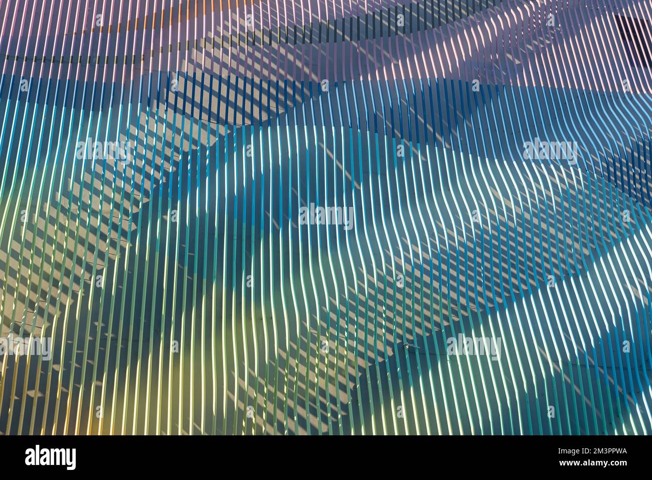 Abstract building wall design. Multicolored metal lines in the design ...