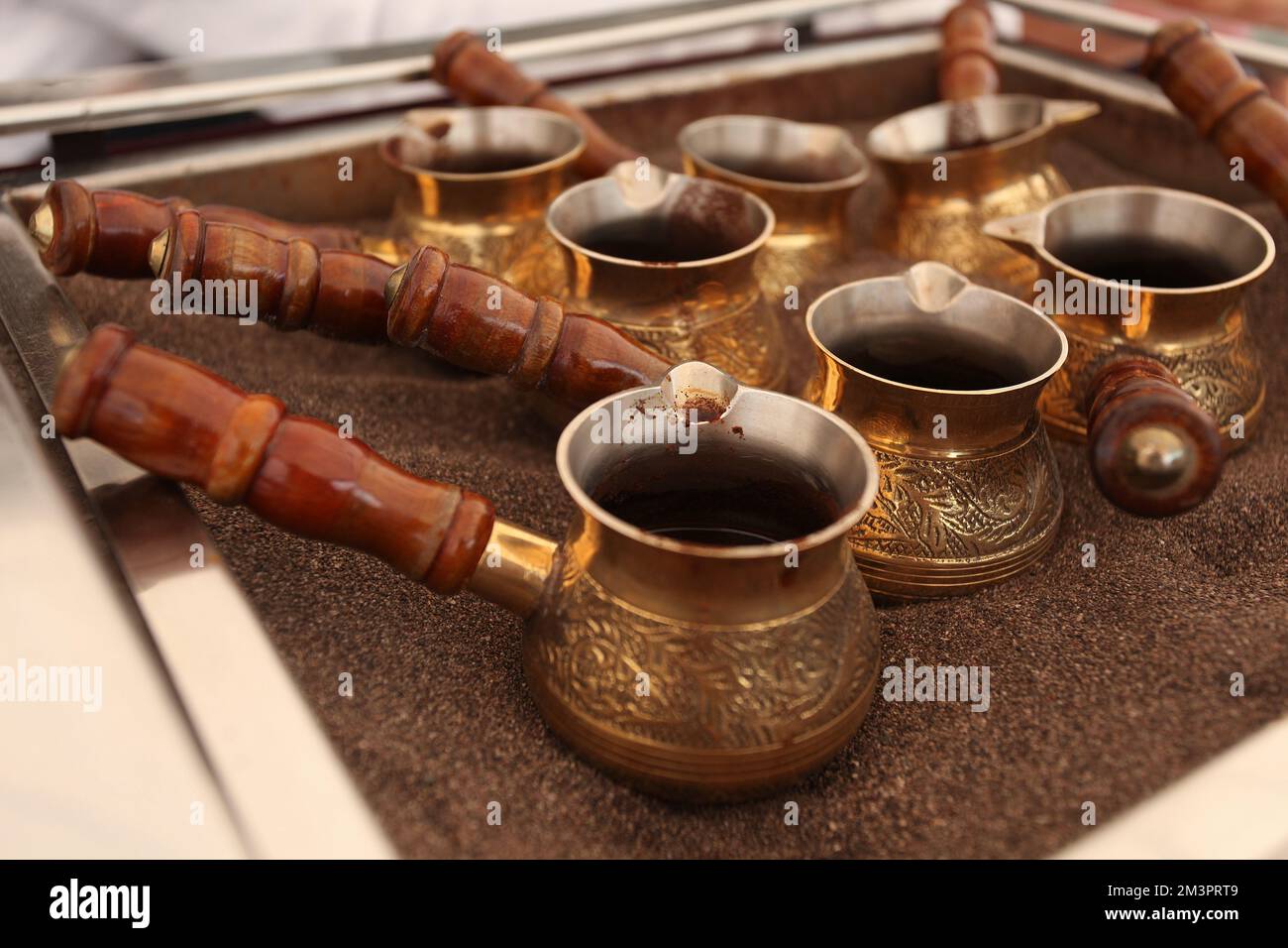 A closeup shot of coffee being made on the hot sand Stock Photo - Alamy