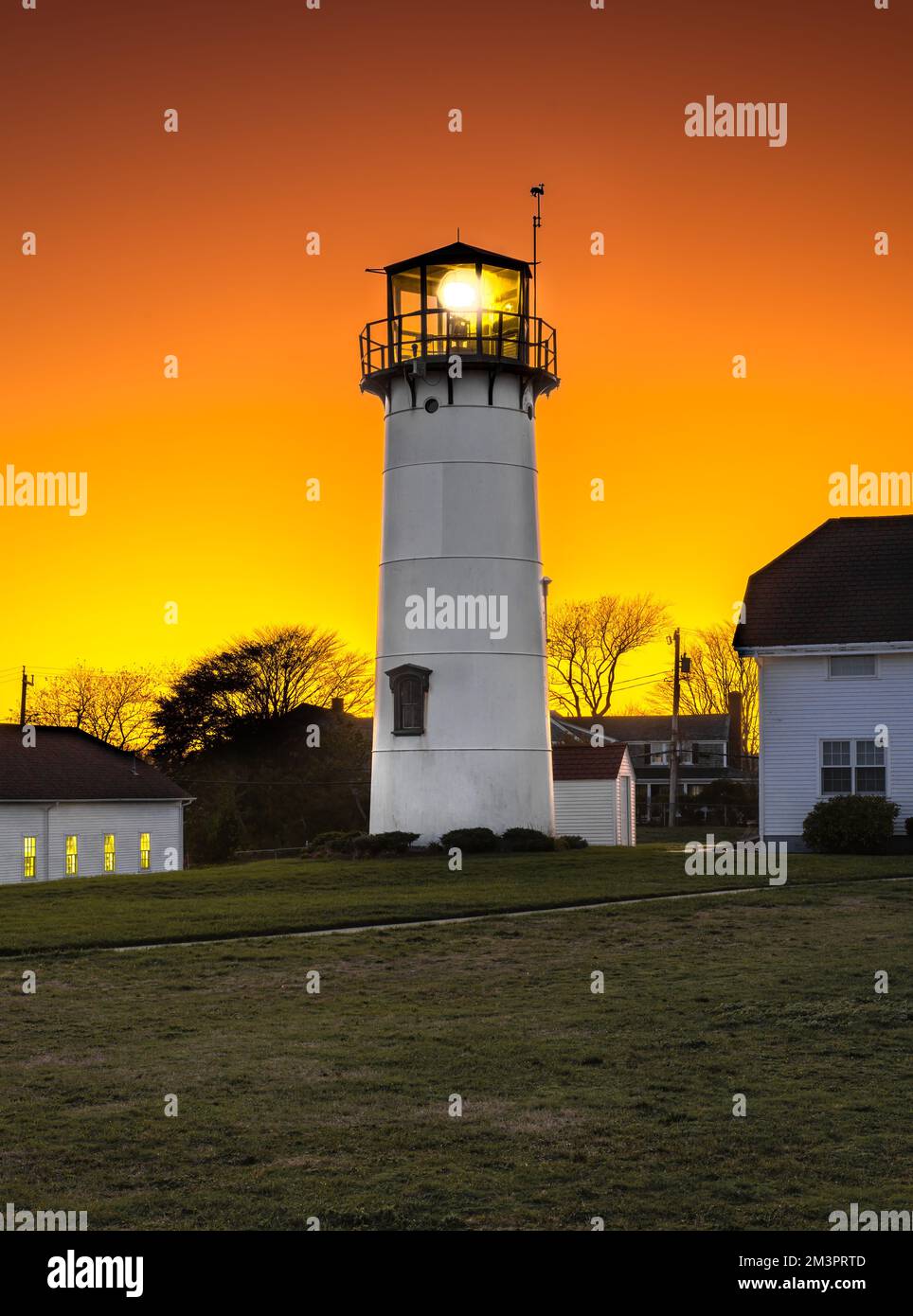 A vertical shot of a lighthouse among rural buildings in Chatham, Cape ...