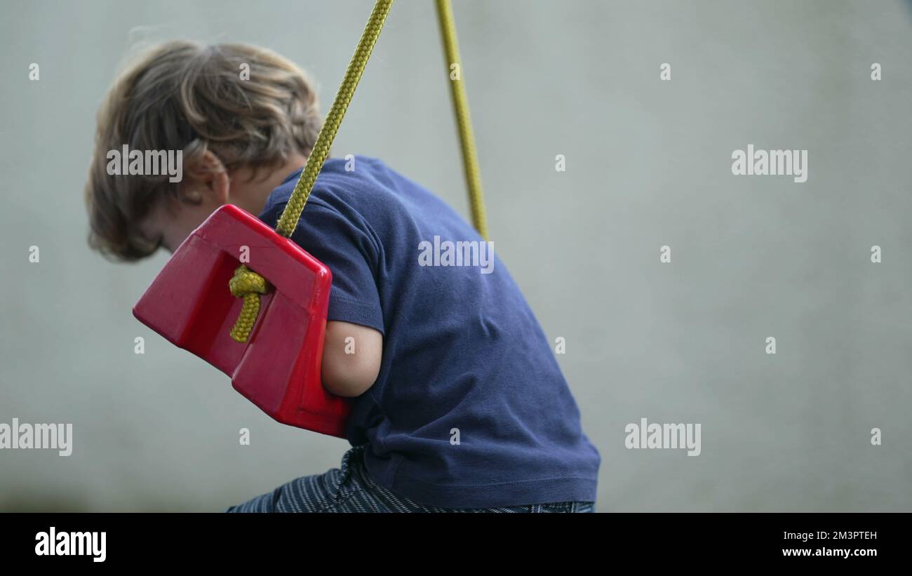 Child twisting and turning at playground swing playful little boy ...