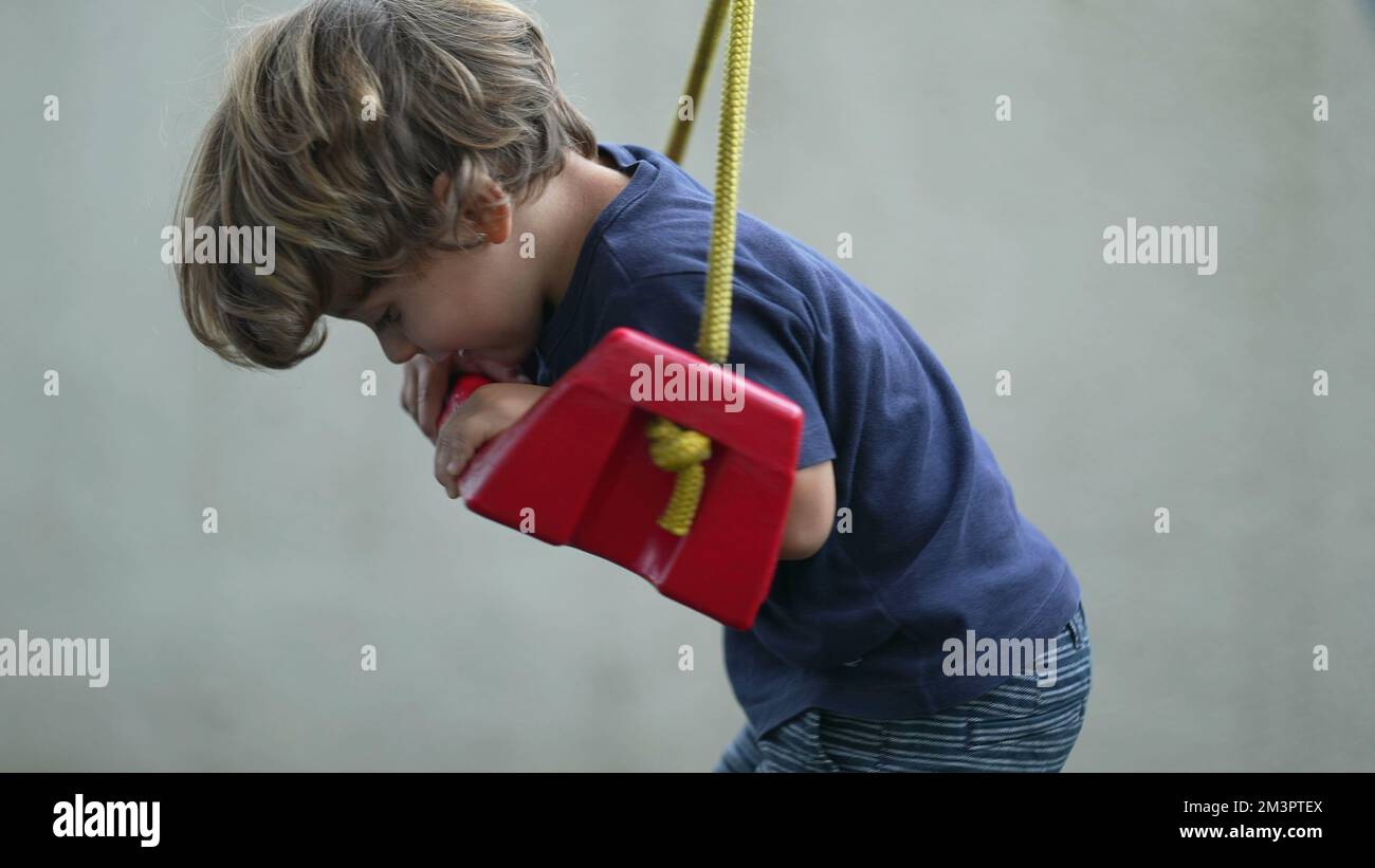 Child twisting and turning at playground swing playful little boy ...