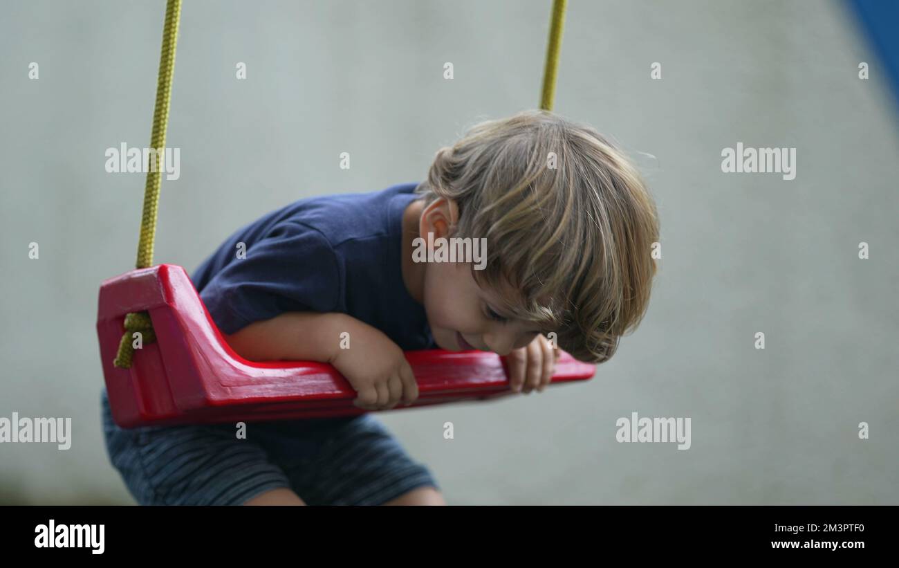 Child twisting and turning at playground swing playful little boy ...