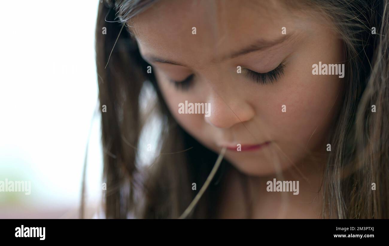 Sad little girl child with eyes closed looking down pensive female ...