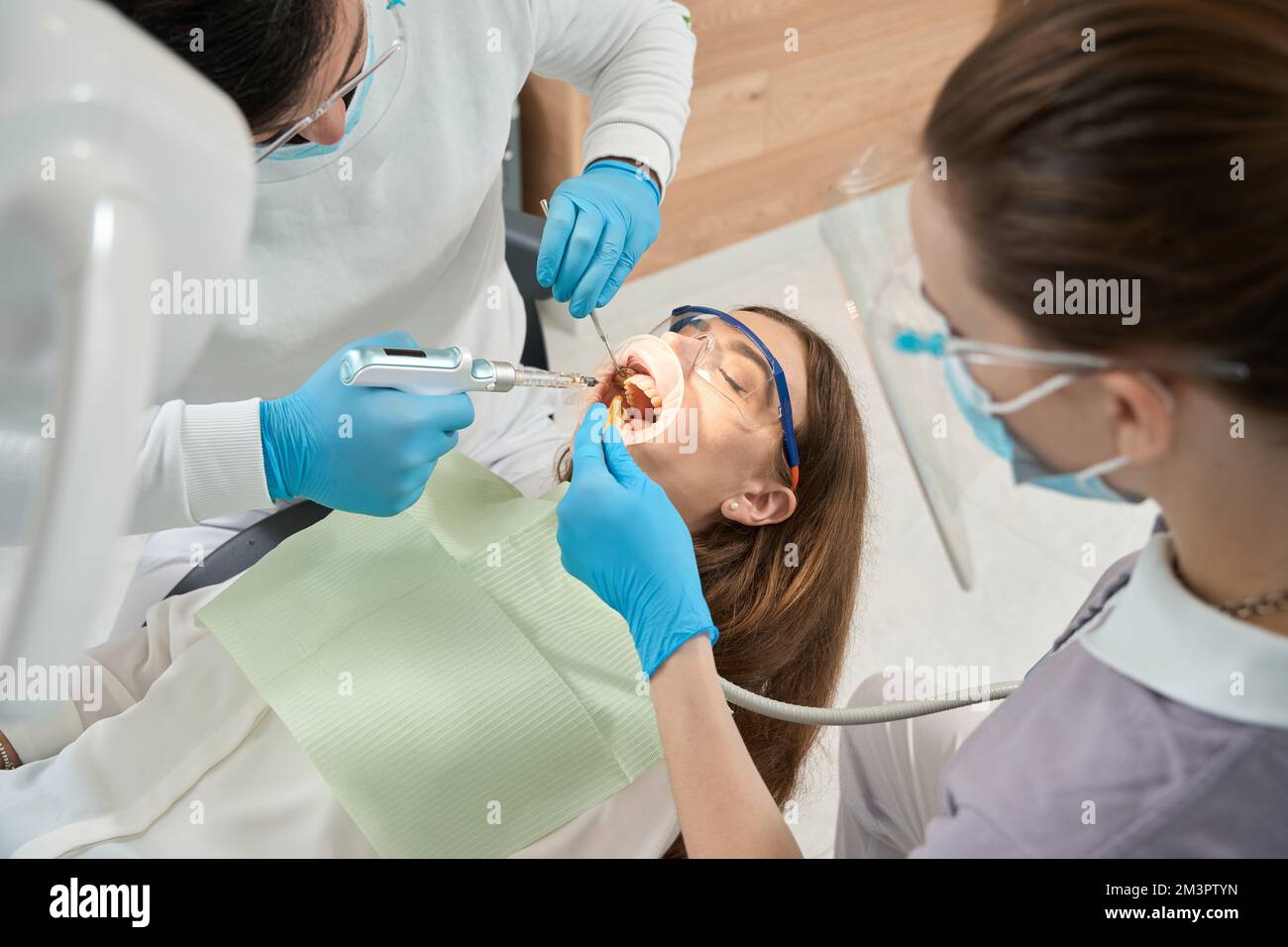 Dental staff preparing female patient for teeth treatment Stock Photo ...