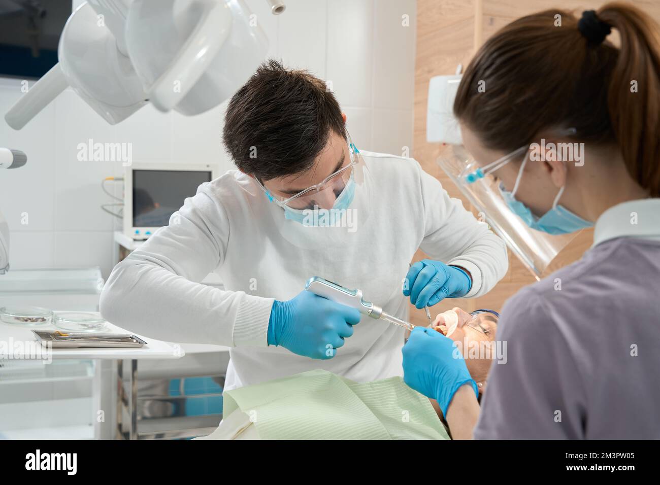 Stomatologist giving anesthesia to client using dental syringe gun ...