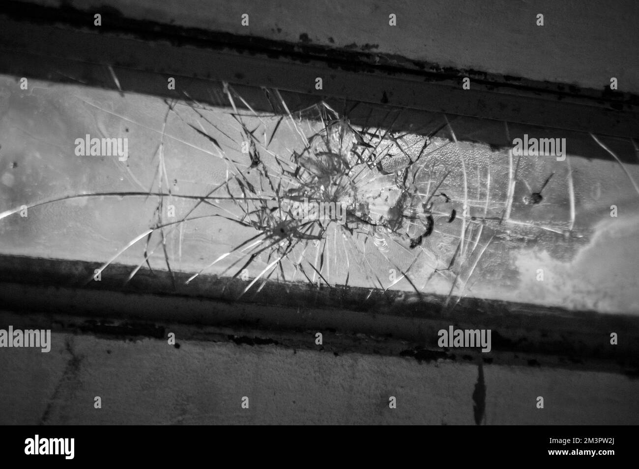A grayscale of shattered window glass on an old wall Stock Photo - Alamy
