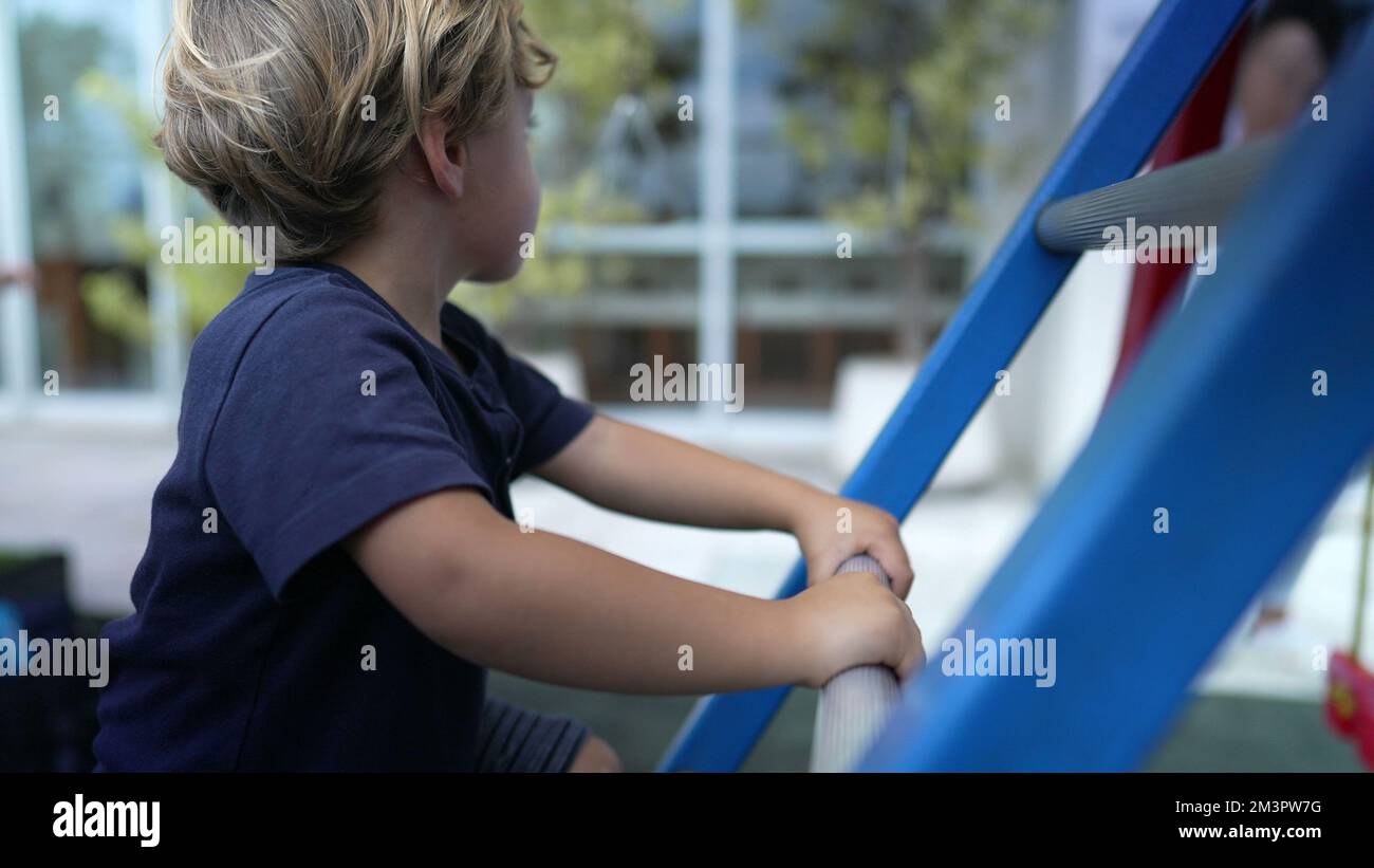 Child climbing playground ladder outside active little boy plays ...