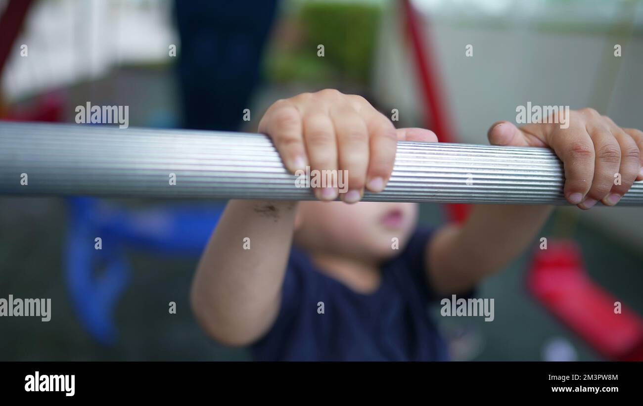 Child holding into monkey bar at playground kid falling down kid falls ...